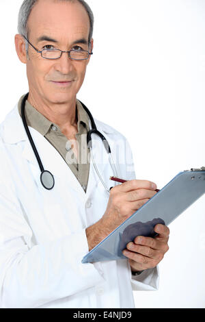 A male surgeon wearing dark grey scrubs and sterile white latex gloves ...