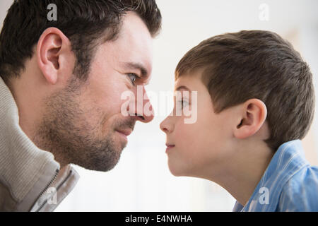 Daddy and kid staring at each other. Adult male and small boy side view ...