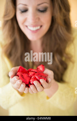 Woman hands holding Valentine's Day gift box on red background. Top ...