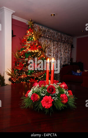 Christmas candles flame red,flowers with illuminated tree to background ...