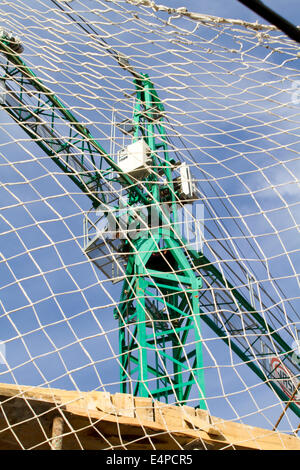 Industrial Crane behind safety net, under construction building ...