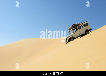A tour guide driving a jeep down a highway in the desert in Egypt Stock ...