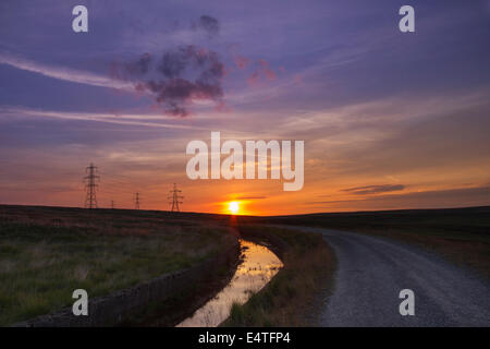 Sunset on the moors with pylons Stock Photo - Alamy