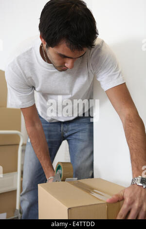 A cardboard box shut by brown adhesive tape - isolated against a white ...