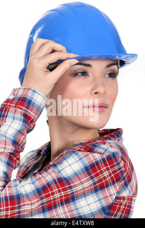 Scanning woman in hard hat and vest, operating handheld barcode scanner ...
