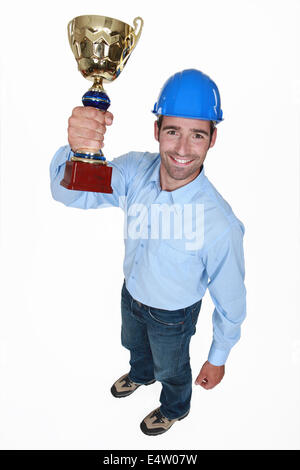 A construction worker holding a trophy Stock Photo - Alamy