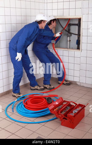 Learning on the job Apprentice gas fitters fit boilers in plumbing ...