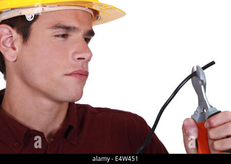 Man carefully cutting electrical wire Stock Photo - Alamy