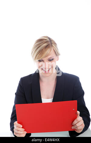 Elated young business woman reading notes on a clipboard with a look of ...
