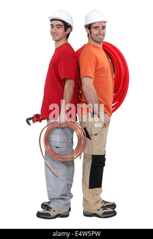 Two plumbers with copper pipe Stock Photo - Alamy