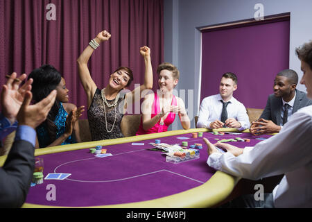 People cheering at poker table Stock Photo - Alamy