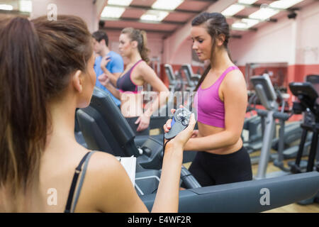 Gym Instructor using stopwatch Stock Photo - Alamy