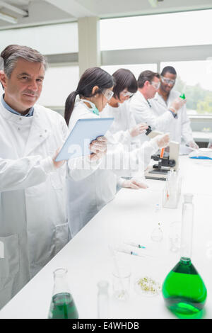 Happy chemist using tablet pc Stock Photo - Alamy