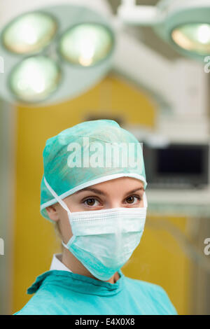 Standing doctor wearing surgical gear and stethoscope, studying green ...
