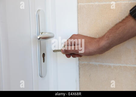 Man putting a key in his front door Stock Photo - Alamy