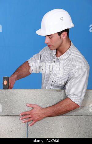 builder knocking wall with hammer Stock Photo - Alamy