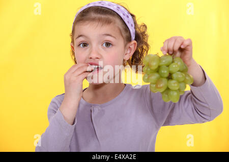 the beautiful girl is eating the green grapes Stock Photo - Alamy