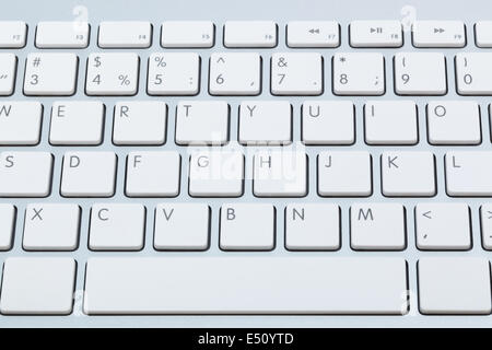 Close up of a white aluminum keyboard on a wooden desk. Macro ...