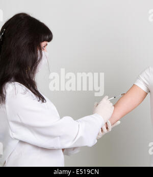 Doctor giving vaccination shot to elderly patient by syringe or ...