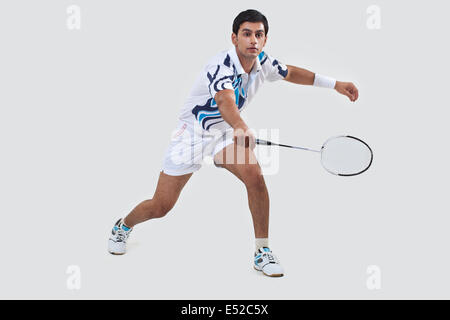 Young man playing badminton over white studio background. Fit male ...