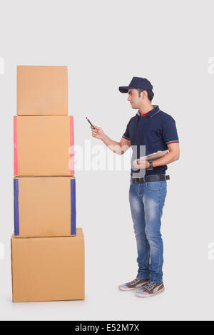 Delivery man counting cardboard boxes Stock Photo - Alamy