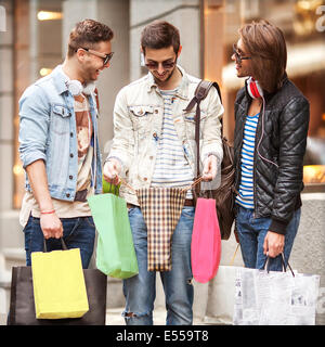 Fashion young guys go shopping with many colored shopping bags in their ...