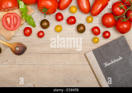 Wooden spoon and book on a wooden board with a checkered tablecloth ...