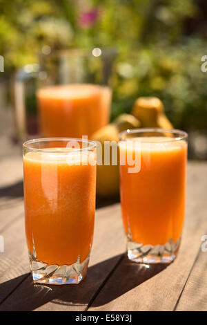 Two glasses of freshly prepared papaya juice with papaya fruits on the ...