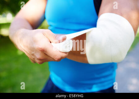 Close-up of male bandaging his arm Stock Photo - Alamy