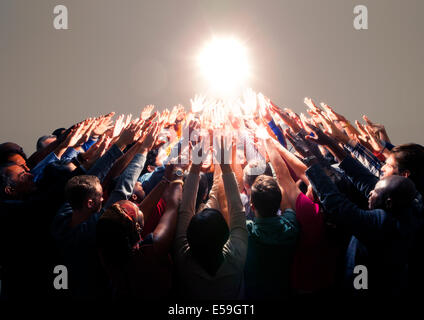 Diverse crowd looking up at bright light Stock Photo - Alamy