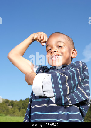 Portrait of african american boy flexing his biceps at the beach Stock ...