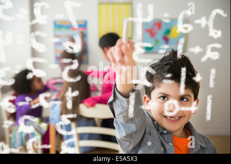 Boy solving math problem in elementary school class at chalkboard Stock ...
