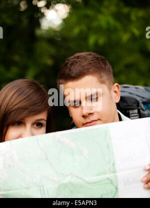 A young female tourist carrying a map and backpack, exploring the the ...