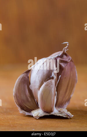 cloves of garlic on scratched yellow wooden background Stock Photo - Alamy