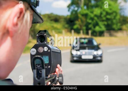 A police officer uses a laser radar gun to catch speeders in New Stock ...