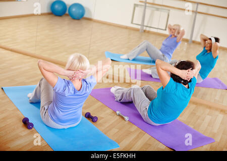 Backs of sporty females doing physical exercise for belly Stock Photo ...