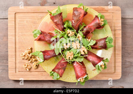 Appetizer with rosettes of cream bresaola with parmesan, rocket and ...