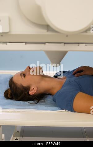 Young woman undergoing a gamma scan examination of the thyroid at the ...