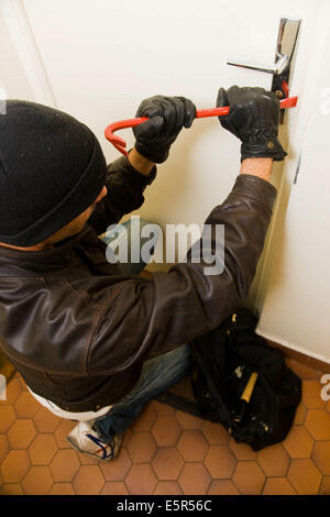 Burglar trying to pry open door Stock Photo - Alamy