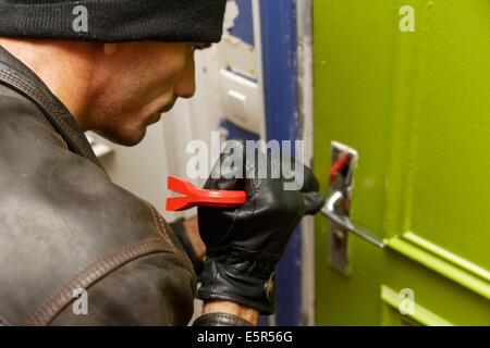 Burglar trying to pry open door Stock Photo - Alamy