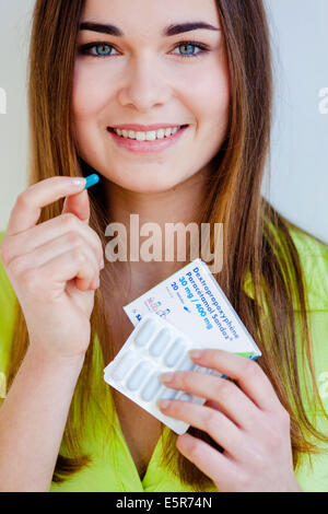 Young woman taking antalgic drug composed of paracetamol and ...