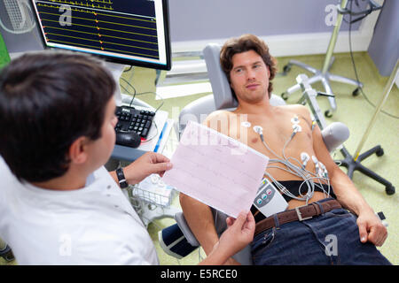 Portable heart monitor. Man wearing a portable electrocardiograph ...