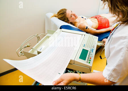 Woman undergoing an electrocardiography (EKG) examination, Department ...