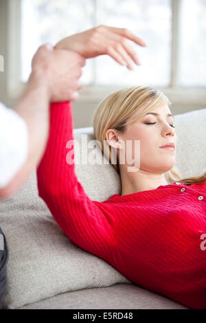 Woman undergoing ericksonian hypnosis, The hand in catalepsy indicates ...