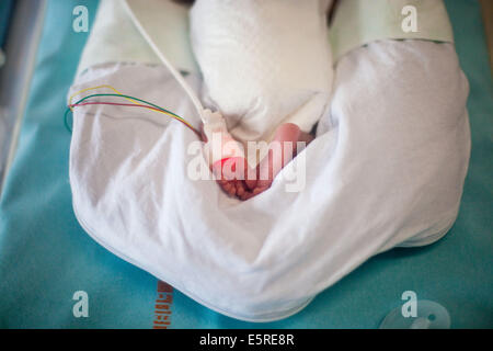 Oxygen meter on the the foot of a premature newborn baby to measure the ...