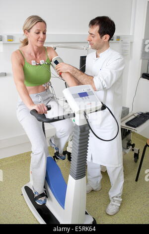 Female patient doing monitored heart rehabilitation training exercises ...