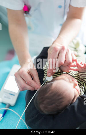 Baby undergoing deafness screening test with the method of otoacoustic ...