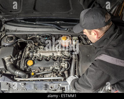 Auto mechanic inspecting car engine compartment Stock Photo - Alamy