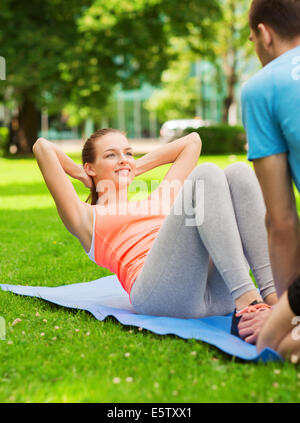 Smiling woman doing abs exercises on mat Stock Photo - Alamy