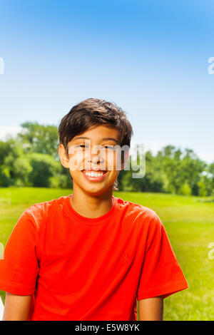Brunet smiling boy in red T-shirt portrait Stock Photo - Alamy
